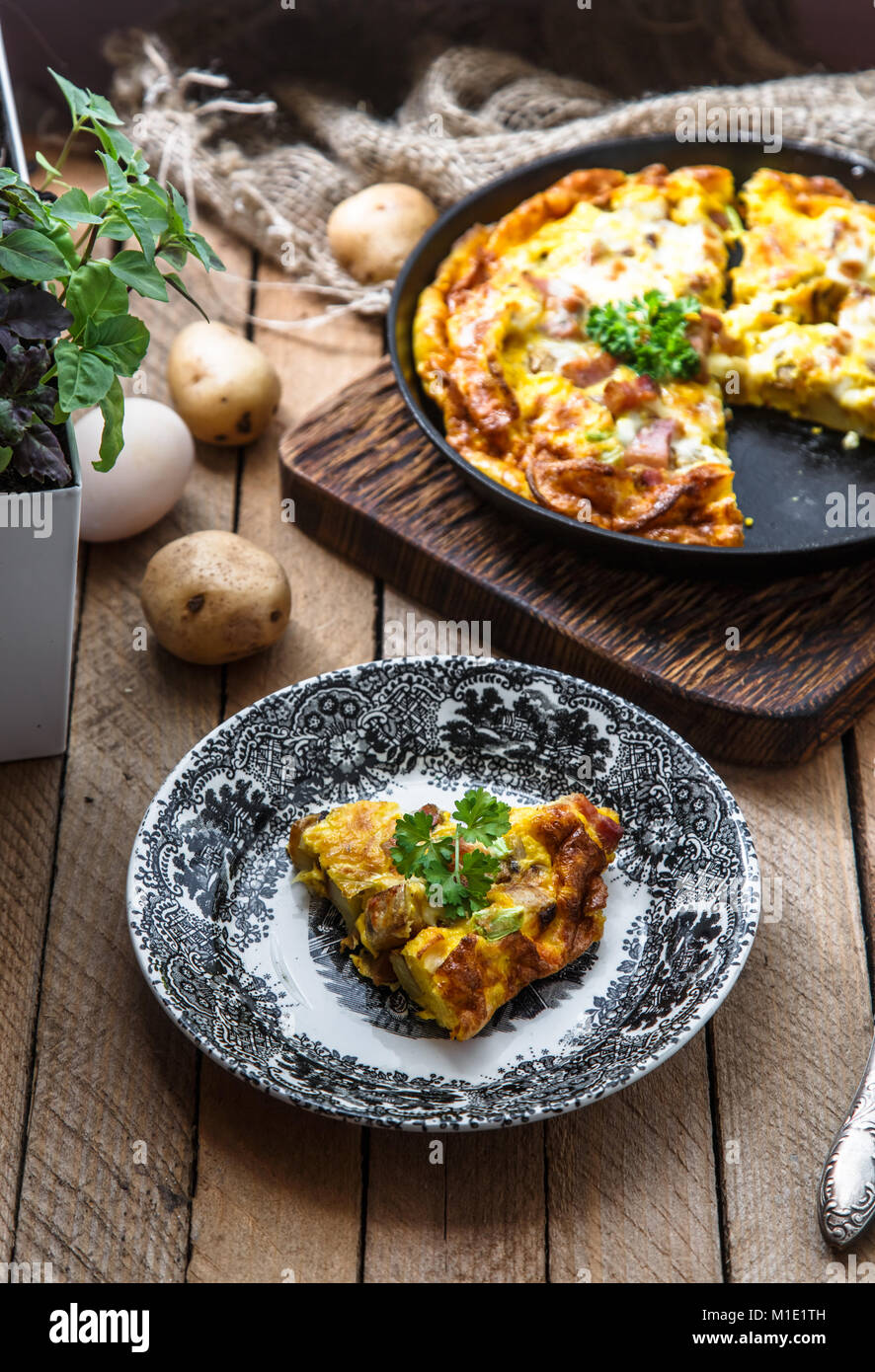 A piece of french baked omelette with ham, cheese, potato and leek on a ...