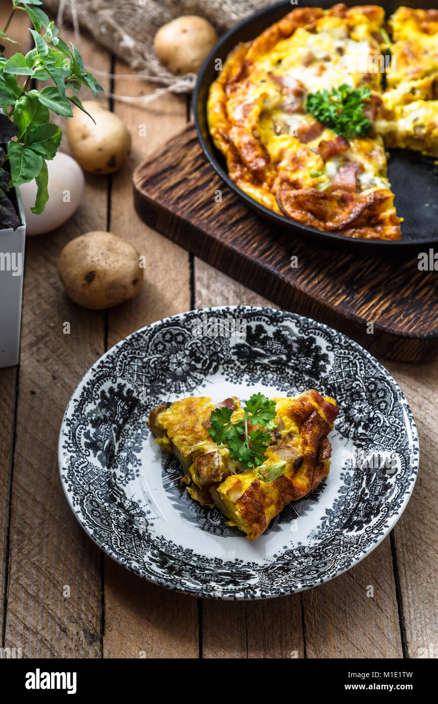 A piece of french baked omelette Savoyarde with ham, cheese, potato and ...