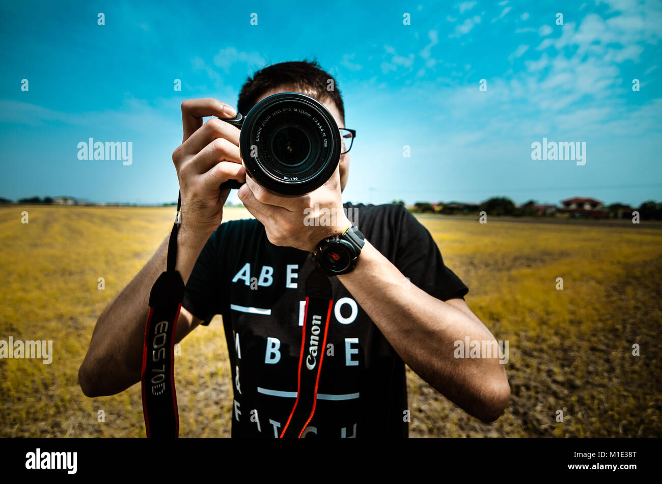 Asian male photographer taking photo Stock Photo - Alamy