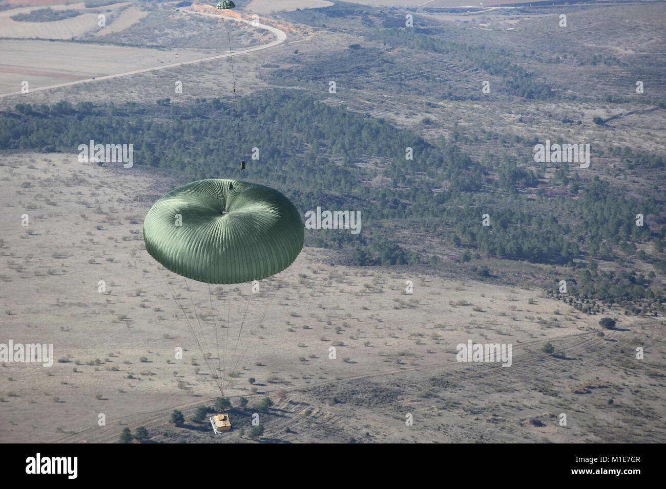 A pallet descends to the ground from a U.S. Marine Corps KC-130J ...