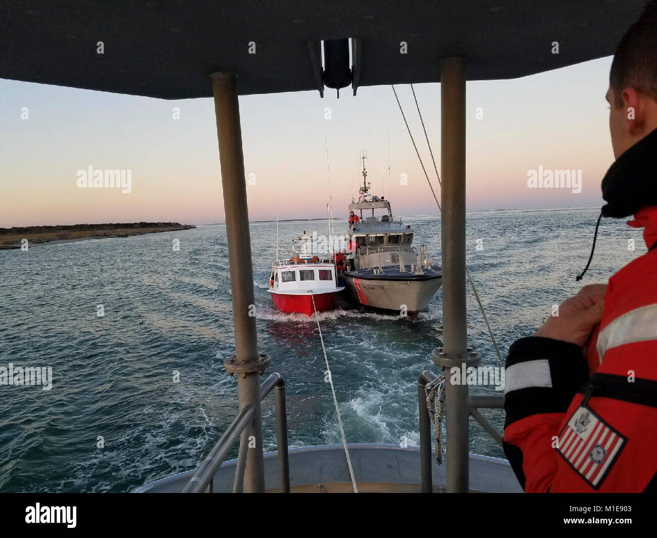 A Coast Guard Station Hatteras Inlet boat crew transfers a crew member ...