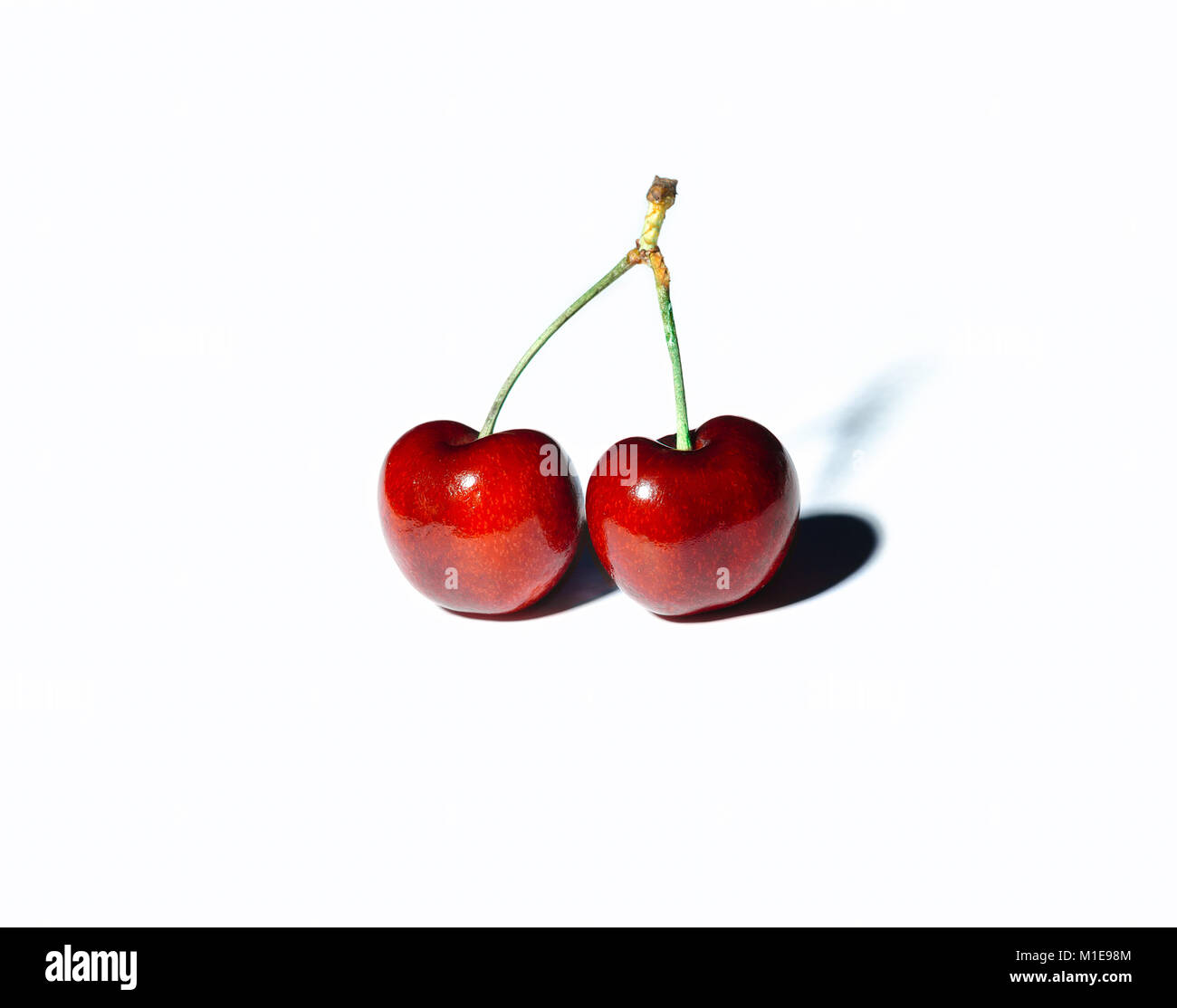 Two cherries isolated on white background Stock Photo - Alamy