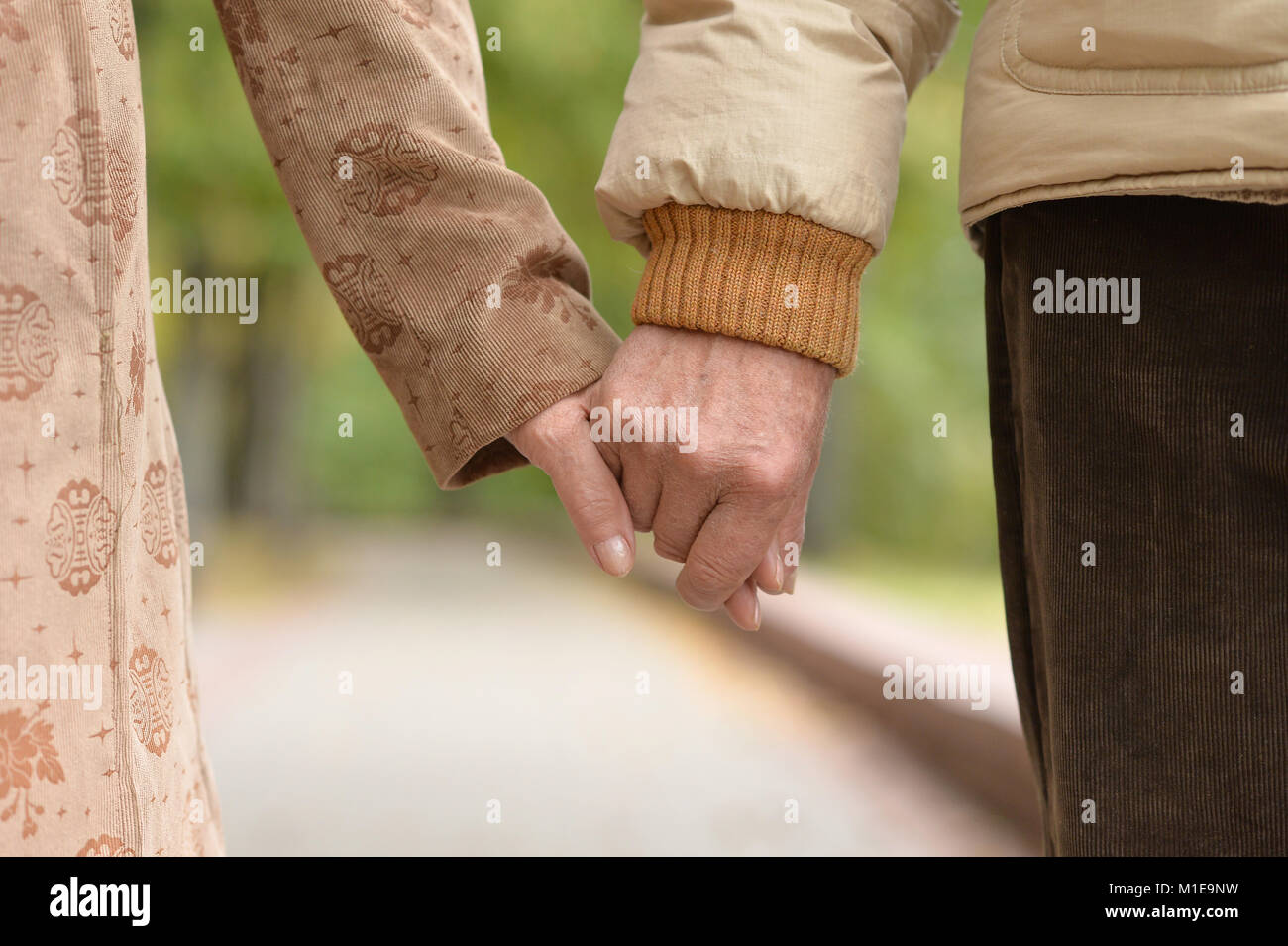 Elderly couple holding hands Stock Photo - Alamy