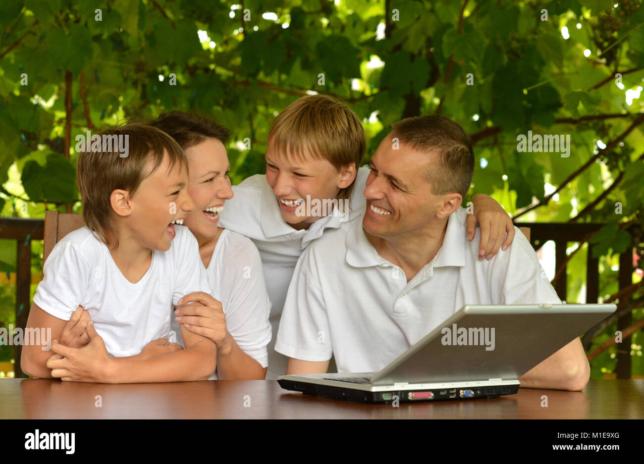 Happy family with laptop Stock Photo - Alamy