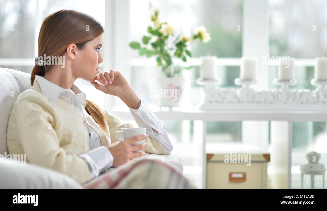 woman sitting in armchair and drinking tea Stock Photo - Alamy