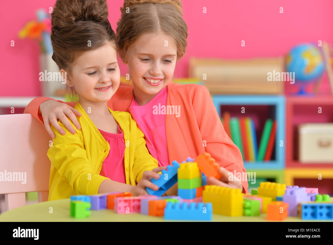 girls playing with colorful blocks Stock Photo - Alamy