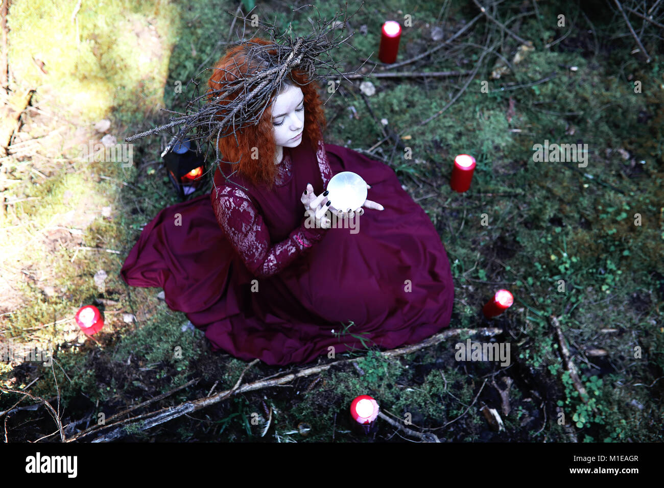The red-haired witch holds a ritual with a crystal ball Stock Photo - Alamy