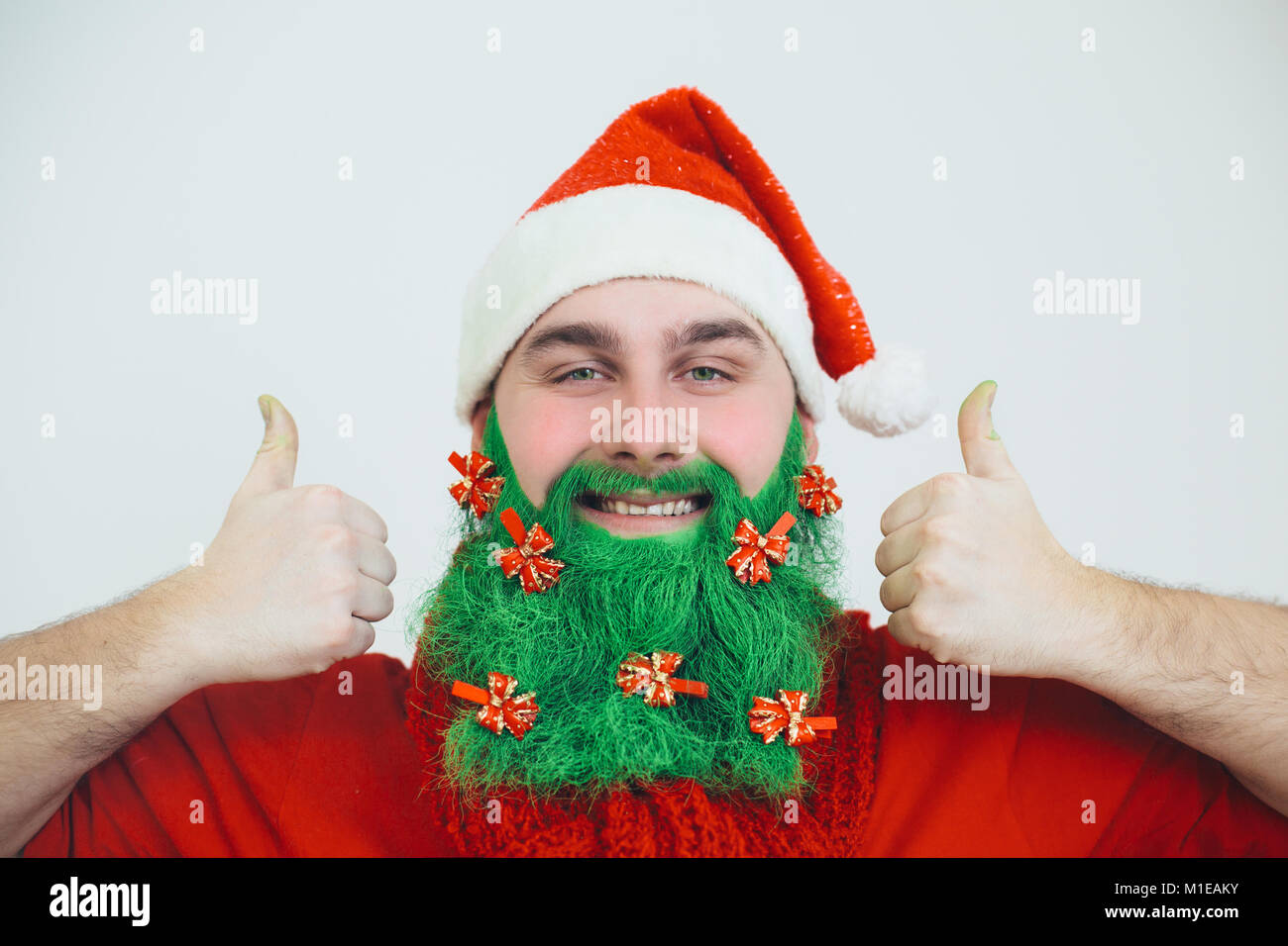 Santa Clause in red clothes with green beard decorated with red bows ...