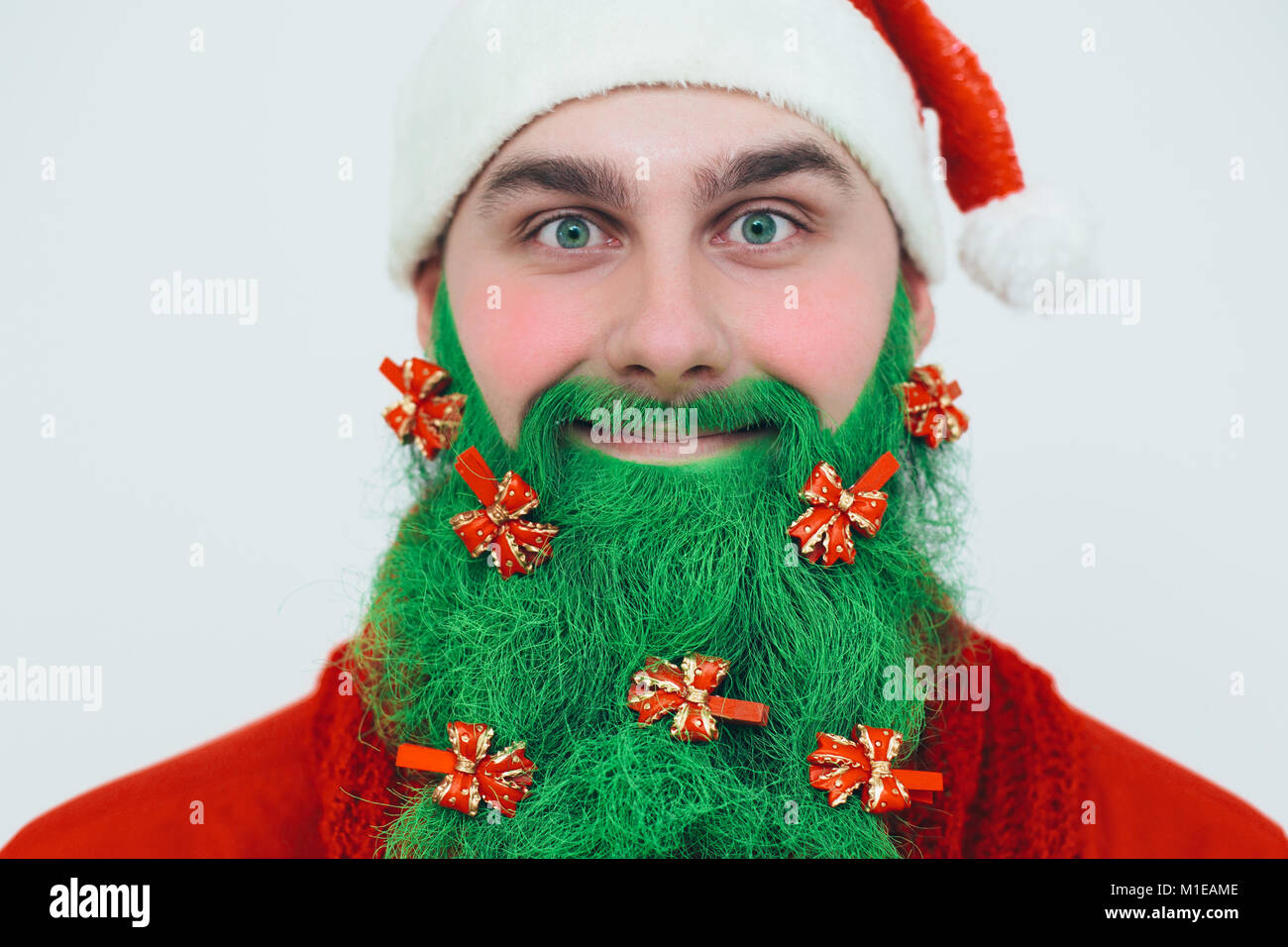 Santa Clause in red clothes with green beard decorated with red bows ...
