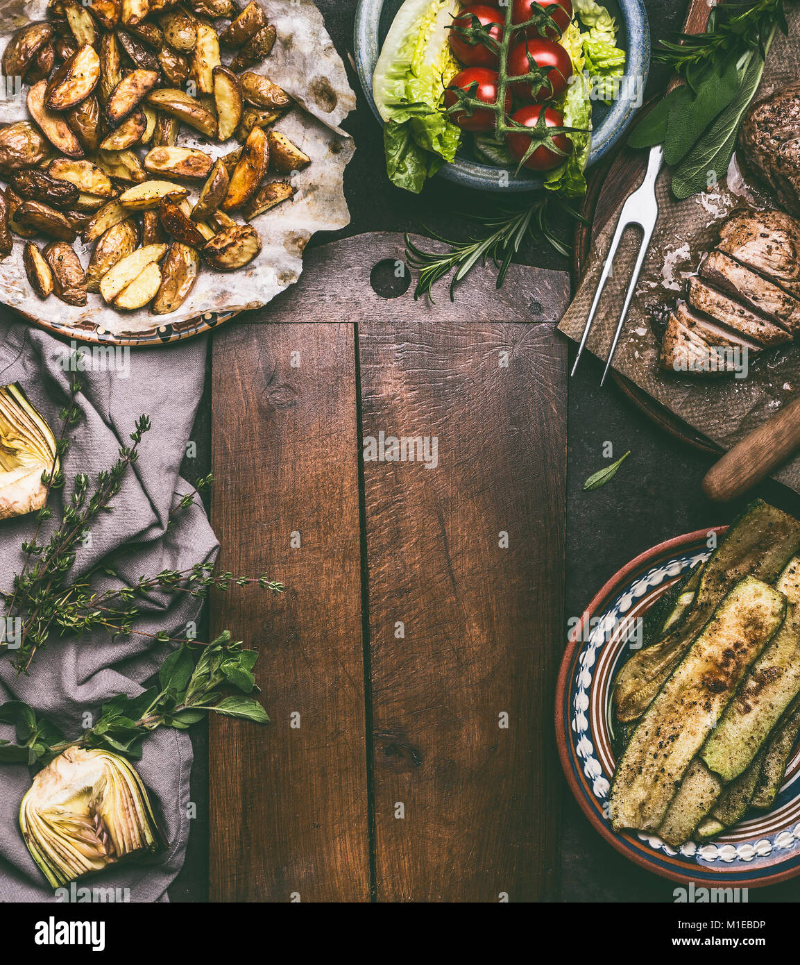 Rustic food background with sliced fried pork meat, baked potatoes ...