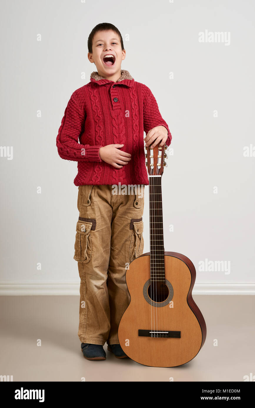 Boy having fun with guitar, making music and singing Stock Photo - Alamy