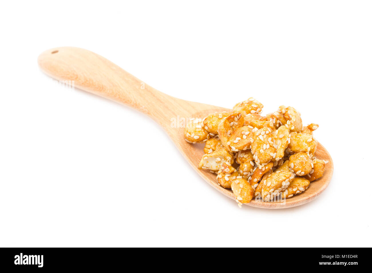 Crispy sugared nuts with wooden spoon isolated on white Stock Photo - Alamy