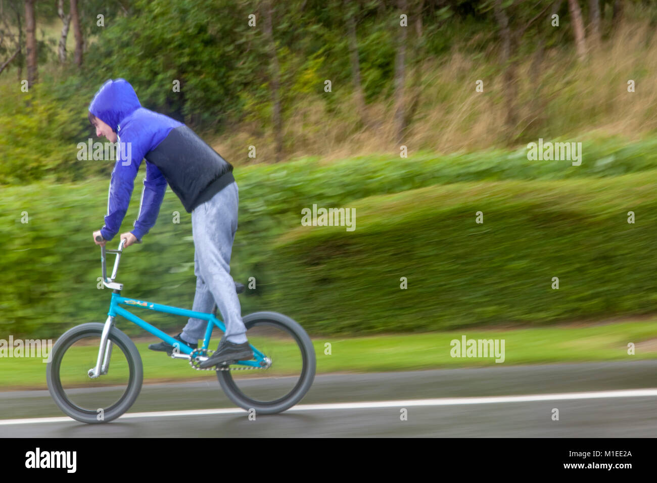 Boy riding a BMX bike at speed down a sloping cycle track Stock Photo ...