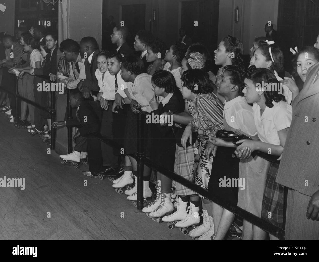 African-American children wearing roller skates, leaning on railing ...