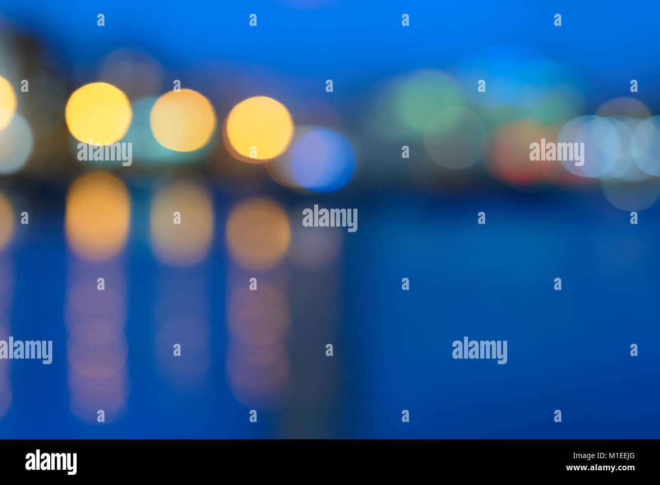 Blurred abstract background of lights over water at night, urban life ...