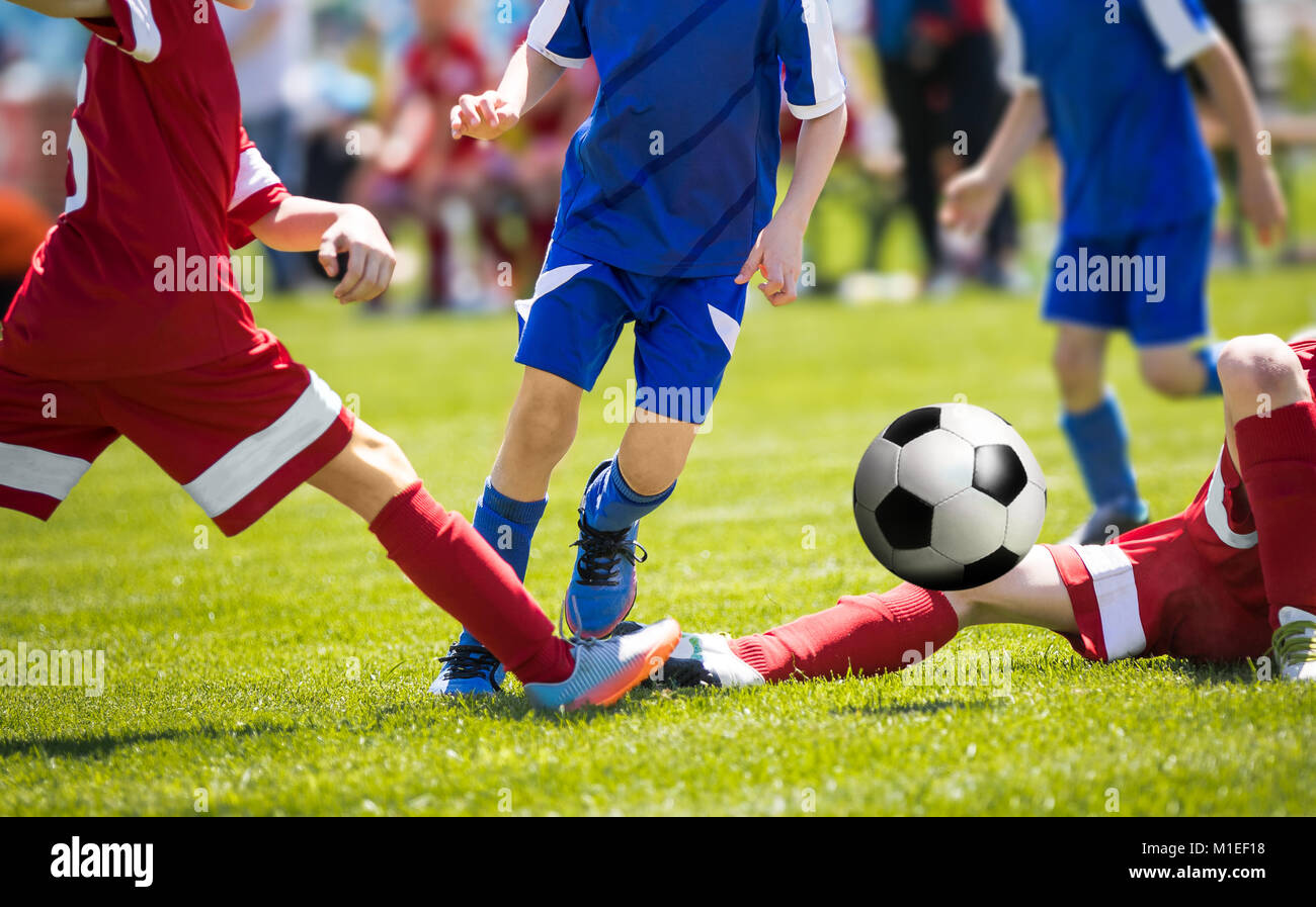 A group of young soccer players runnng the ball. Footballer dribbling ...