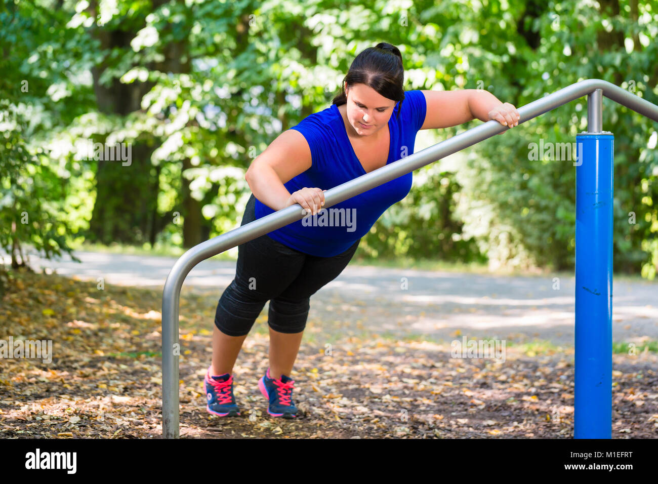 Obese woman doing sport stretching outdoors in park Stock Photo - Alamy