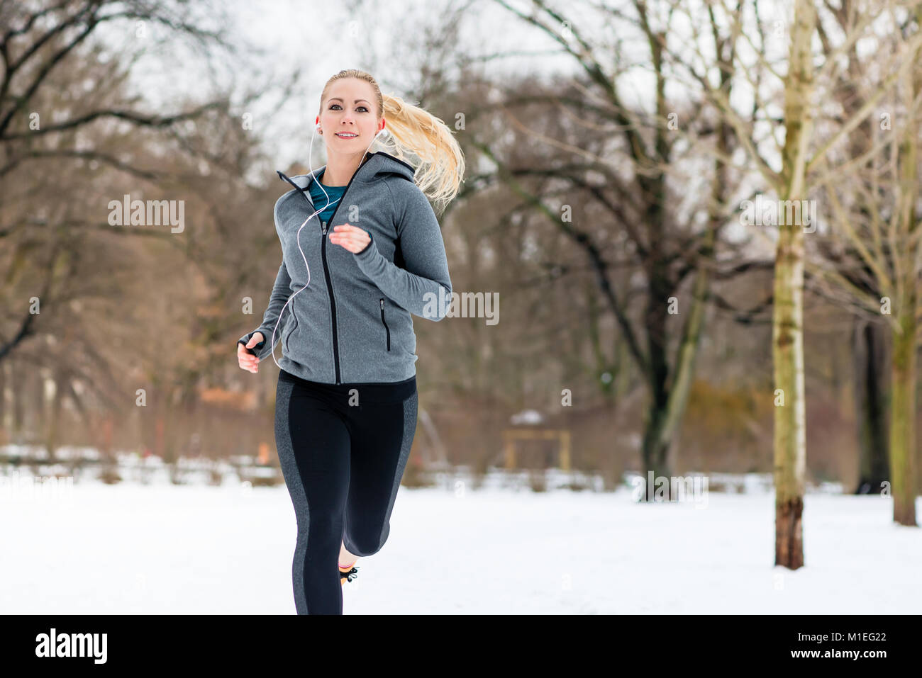 Woman running down a path on winter day in park Stock Photo - Alamy
