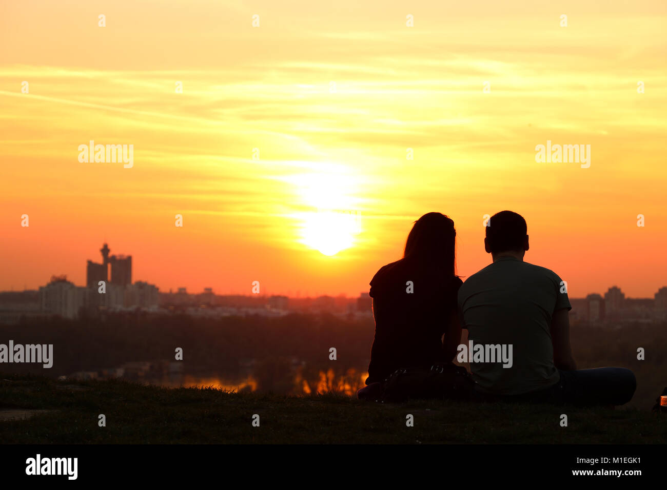 Two people enjoying the sunset Stock Photo - Alamy