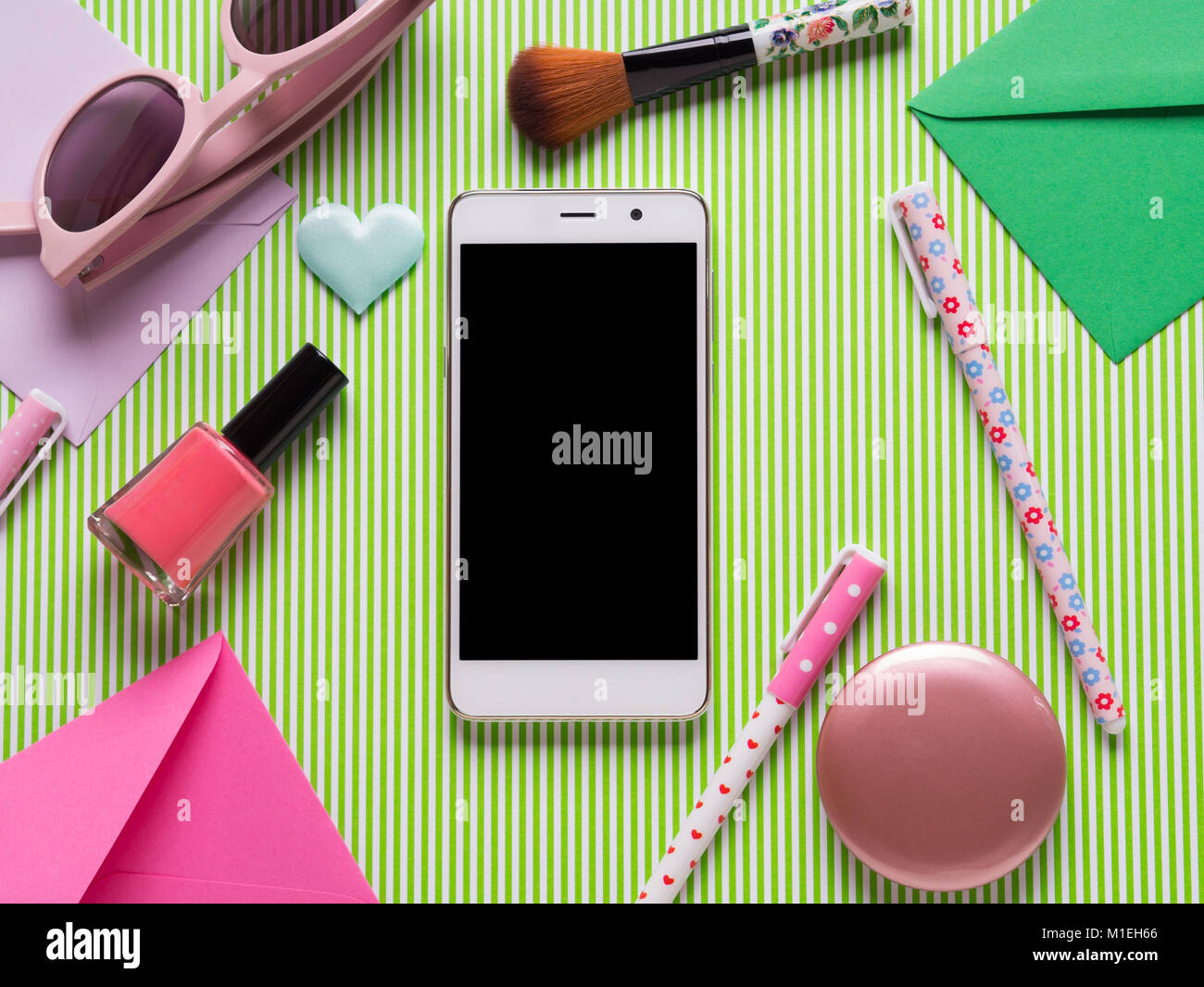 Smartphone black screen and make up girl's accessories flat lay. Girl's ...