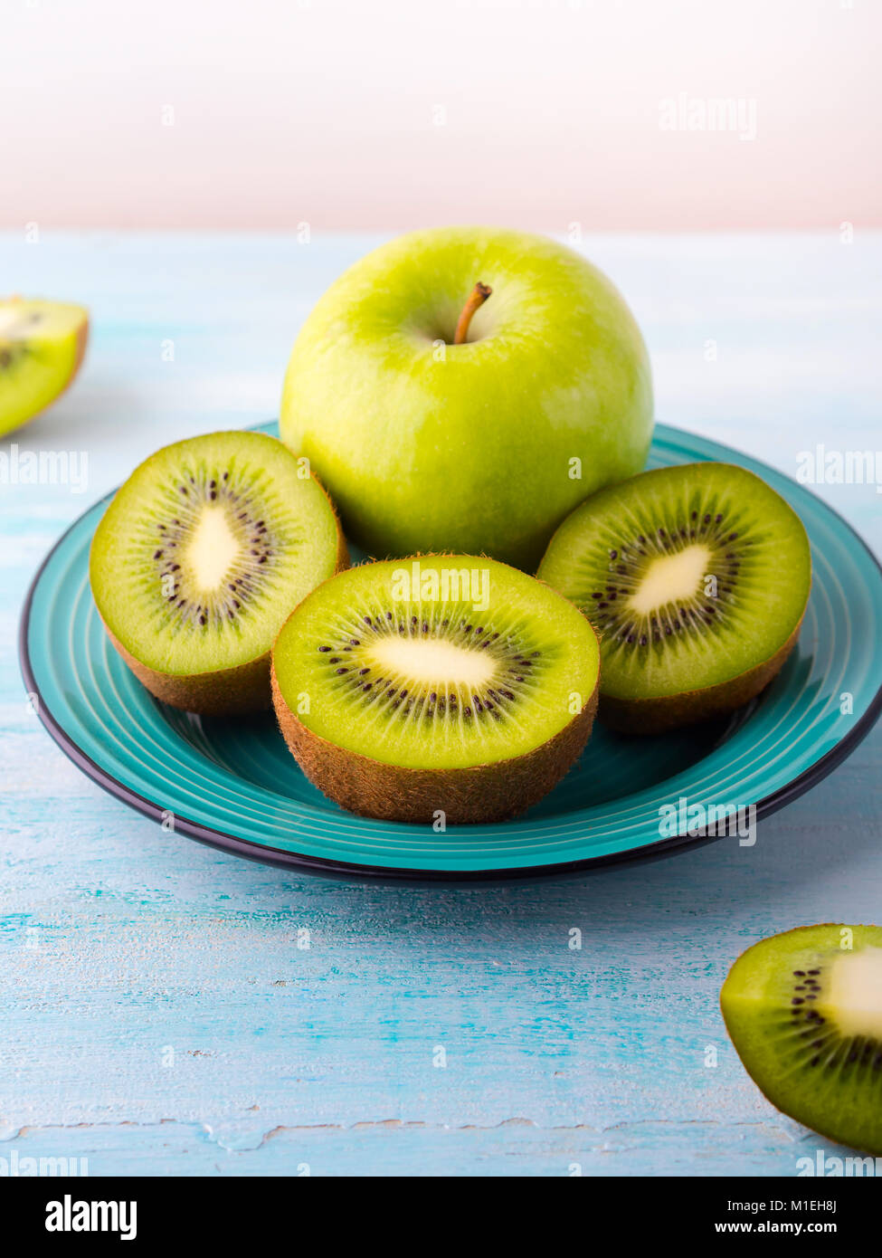 Green apples and kiwi on turquoise background Stock Photo - Alamy