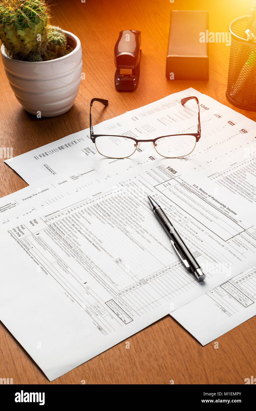 US tax forms on the table with the eyeglasses, pen and cactus. Useful ...