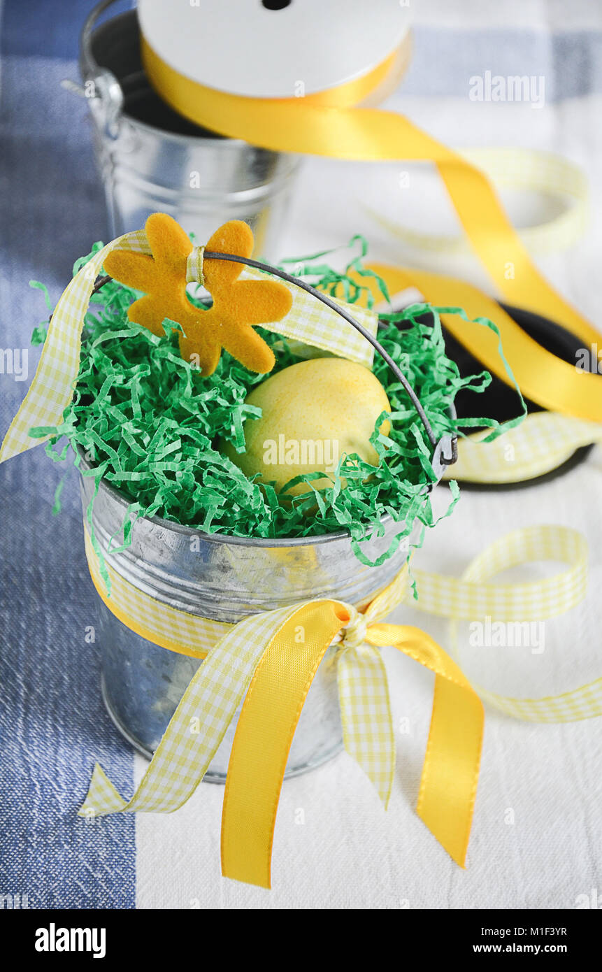 Yellow dyed easter egg with yellow deco items in small tin bucket Stock ...
