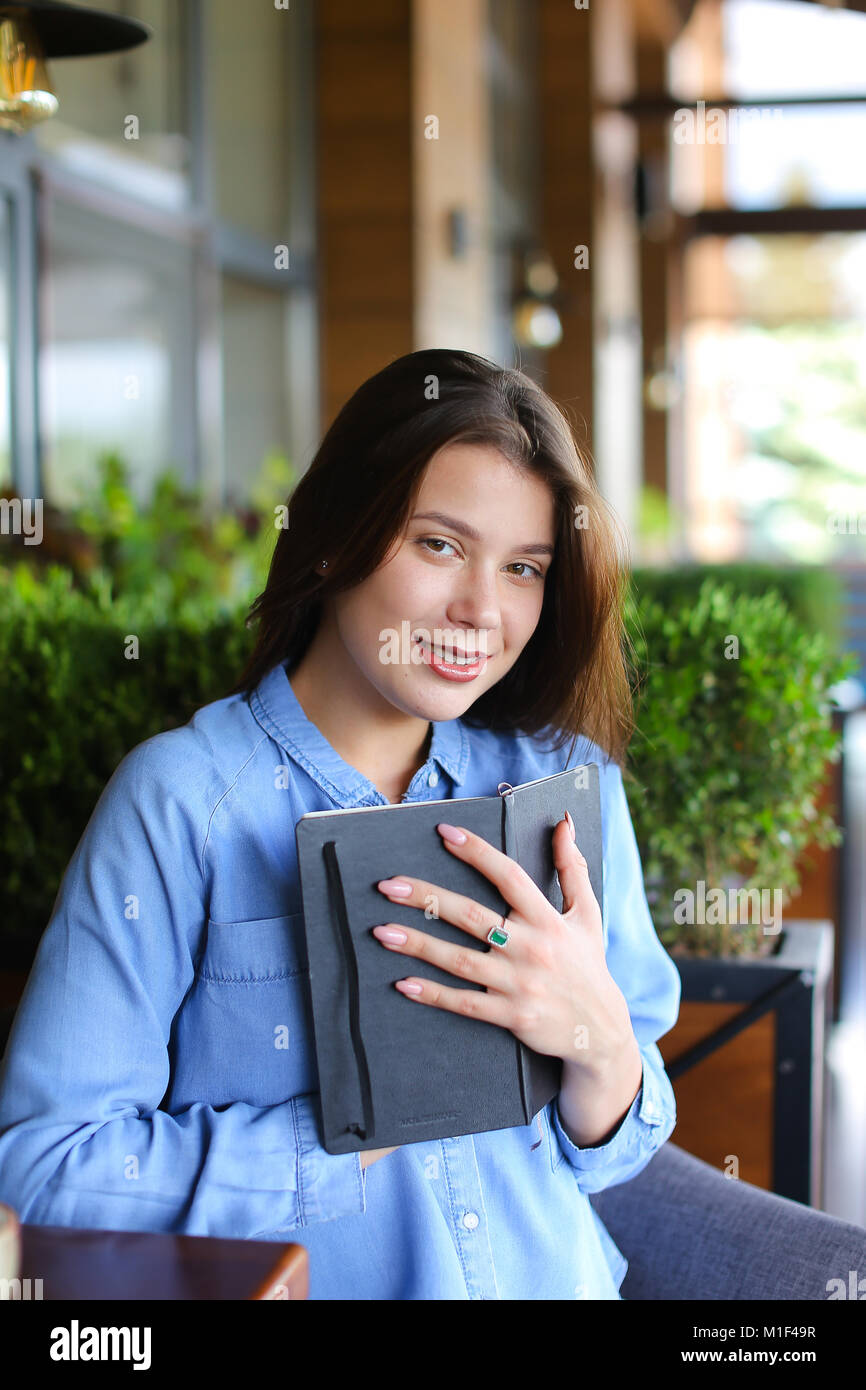 Beautiful girl reading diary at cafe Stock Photo - Alamy