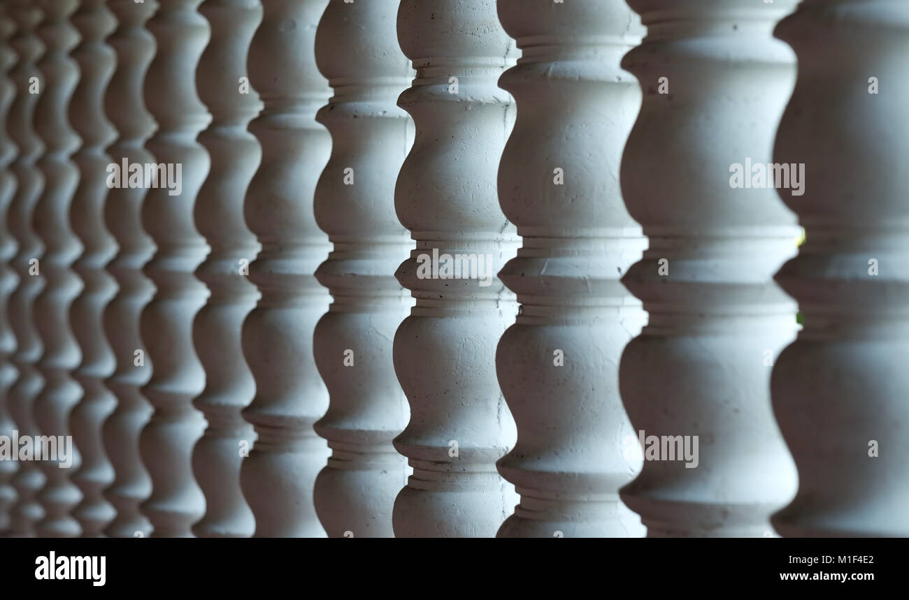 Several white curved columns in one row. Architectural detail of the ...