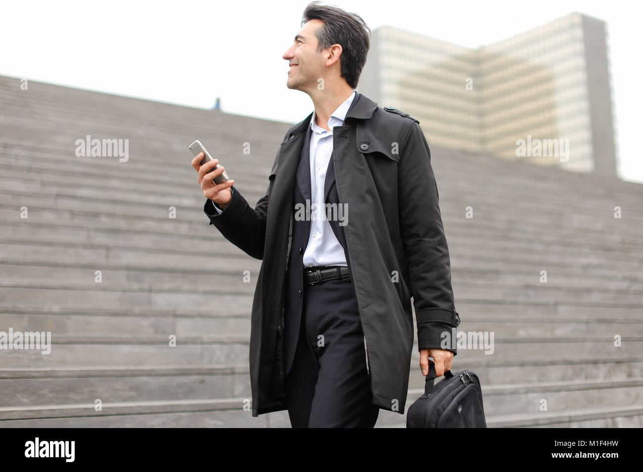 European businessman walking and speaking by telephone Stock Photo - Alamy