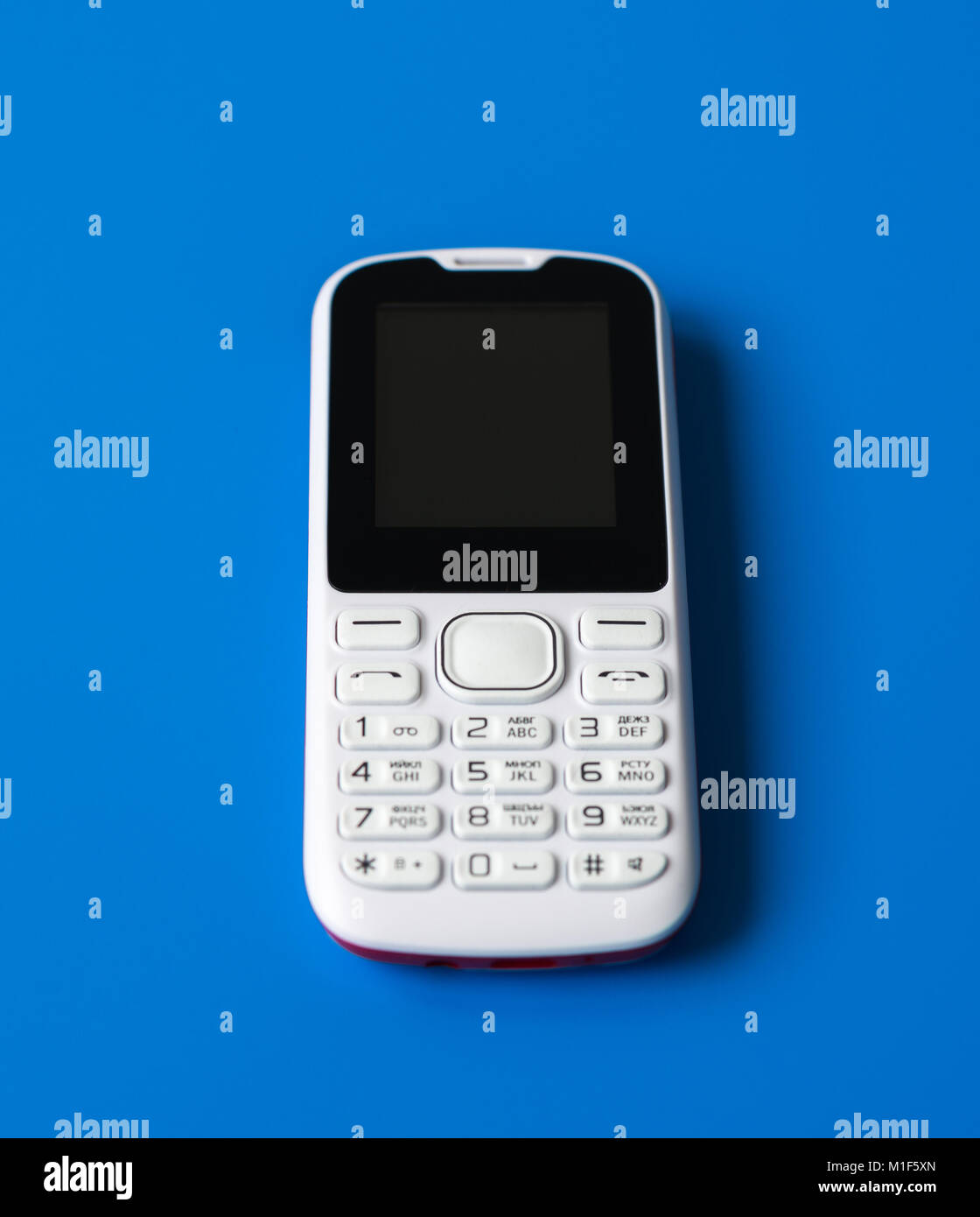 White cell phone with buttons on a blue background Stock Photo - Alamy