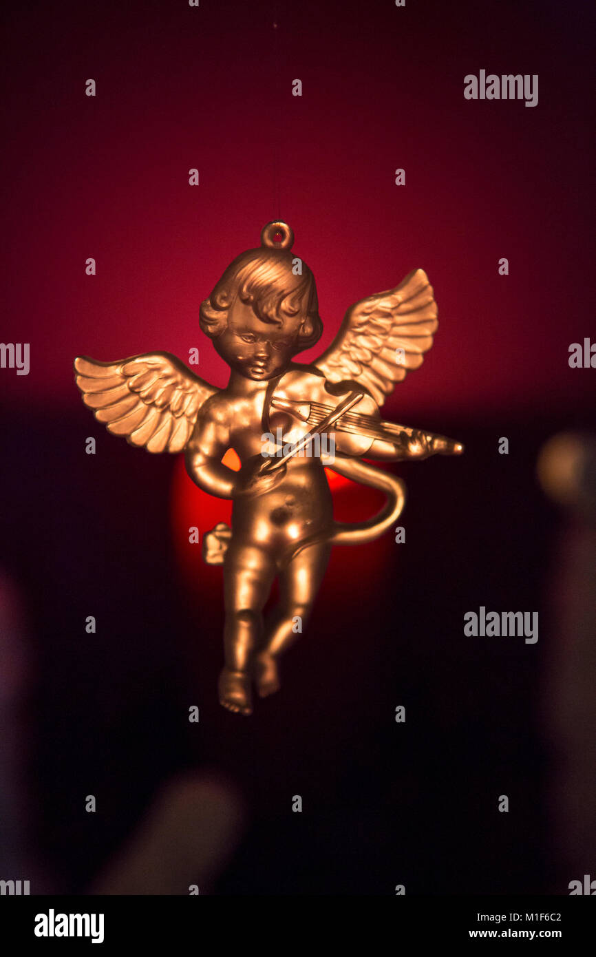 A plastic transparent opaque angel backlit by a candle in a christmas ...