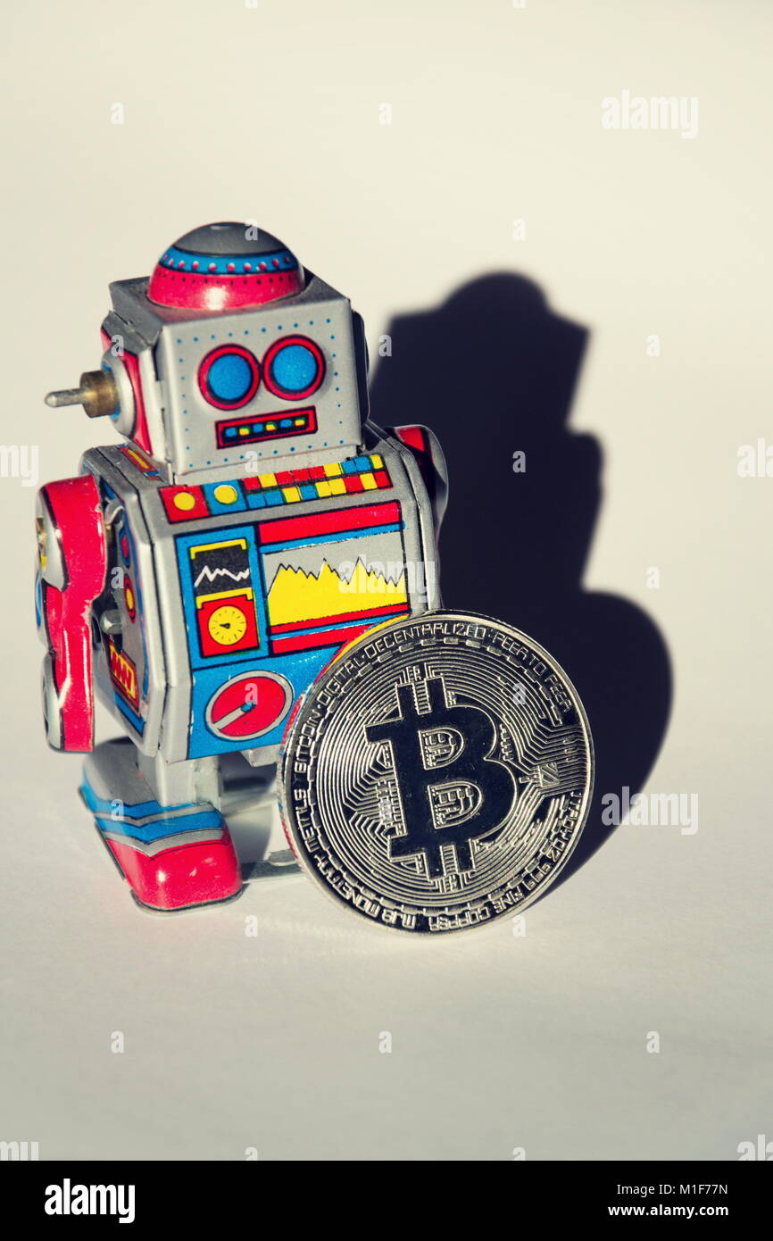 Vintage tin toy robot with bitcoin coin, cryptocurrency mining concept ...