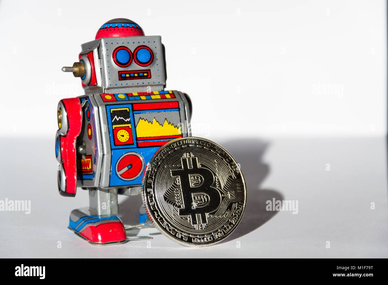 Vintage tin toy robot with bitcoin coin, cryptocurrency mining concept ...