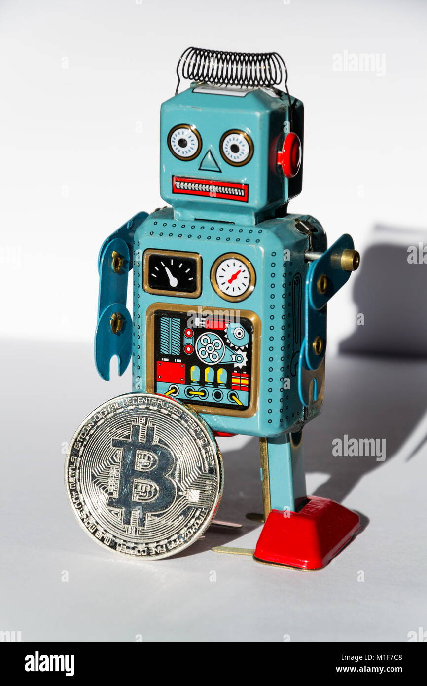 Vintage tin toy robot with bitcoin coin, cryptocurrency mining concept ...