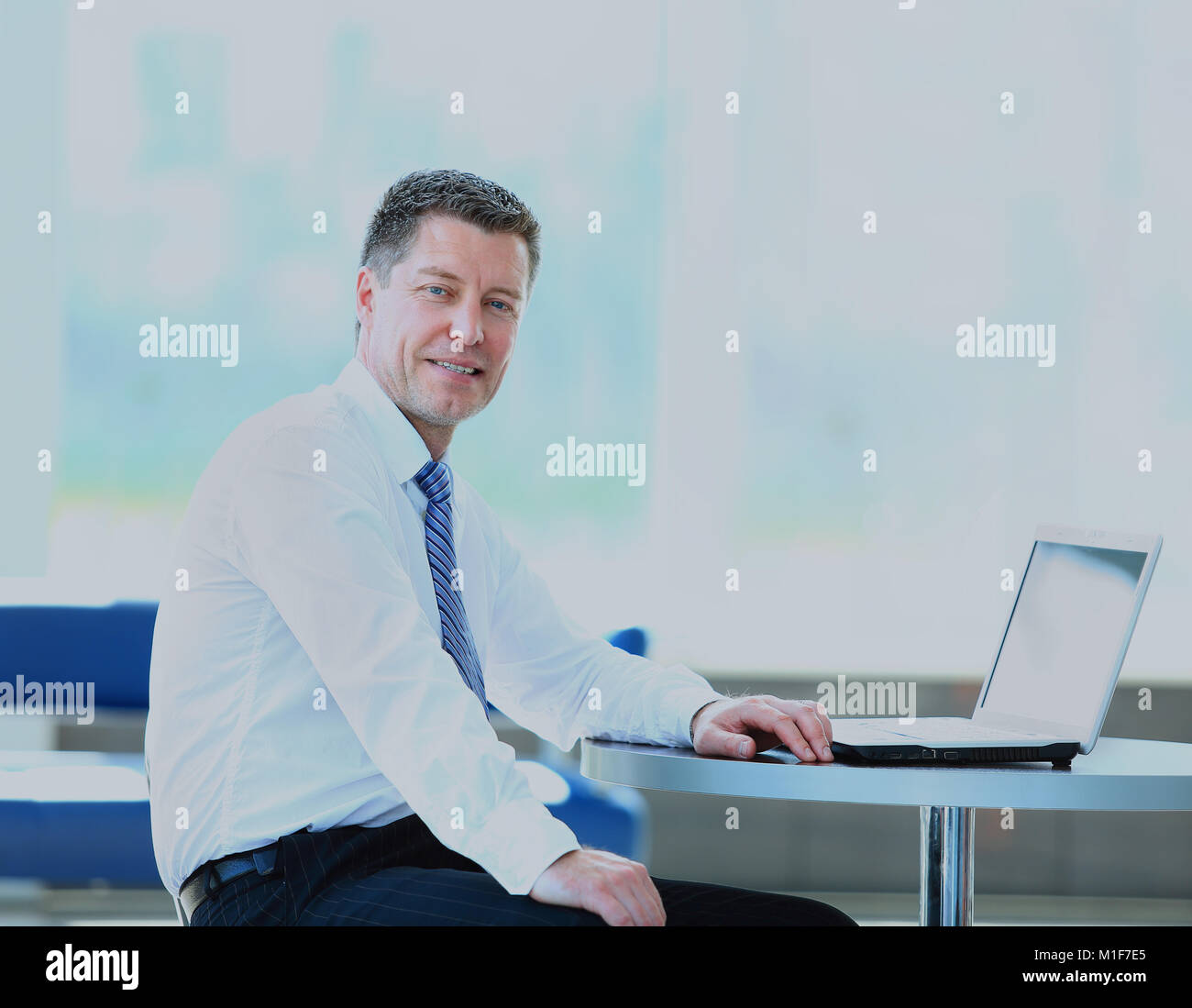 Happy businessman sitting in office Stock Photo - Alamy