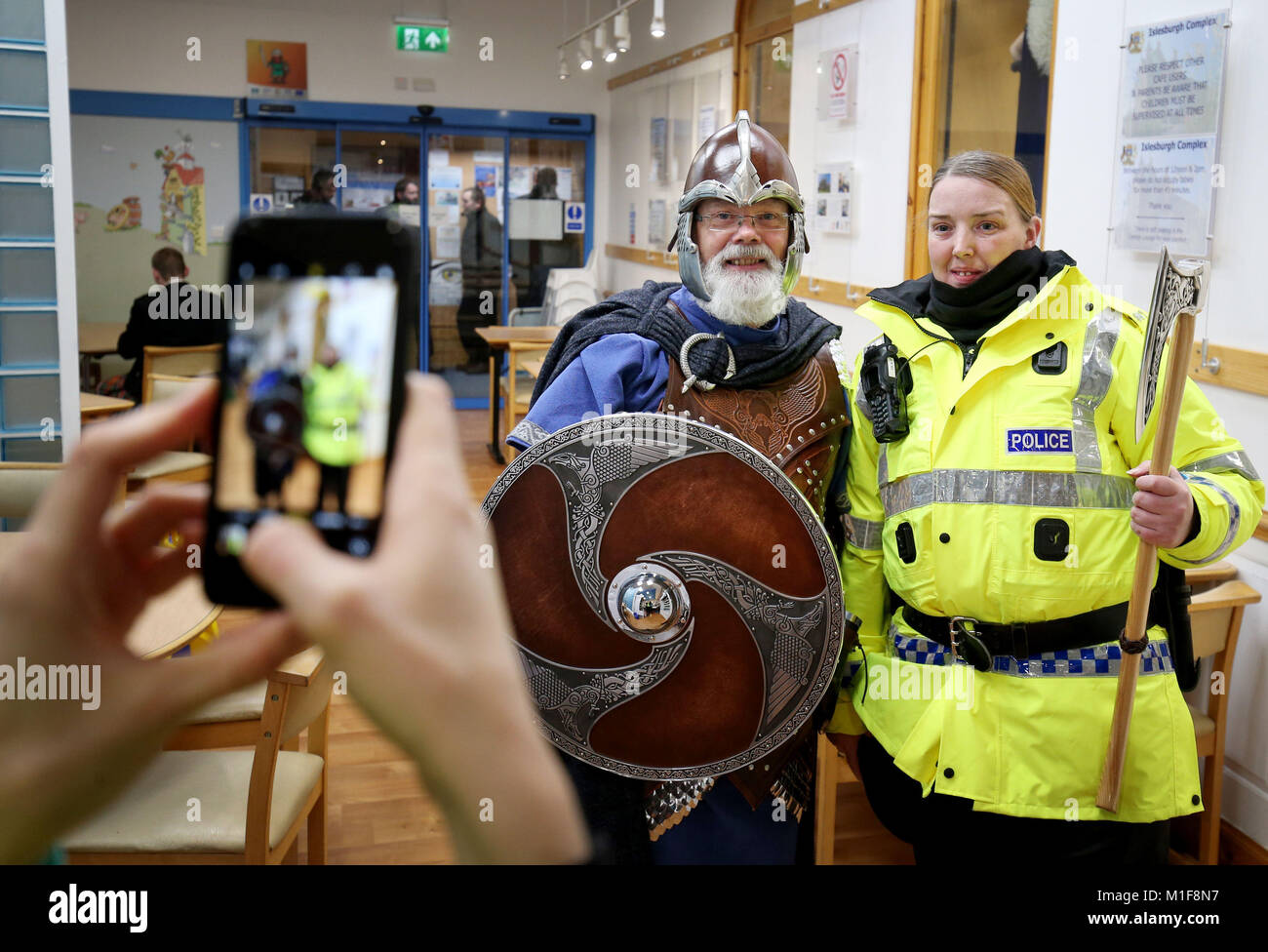 A member of the Jarl Squad poses with a police officer as he gets ...