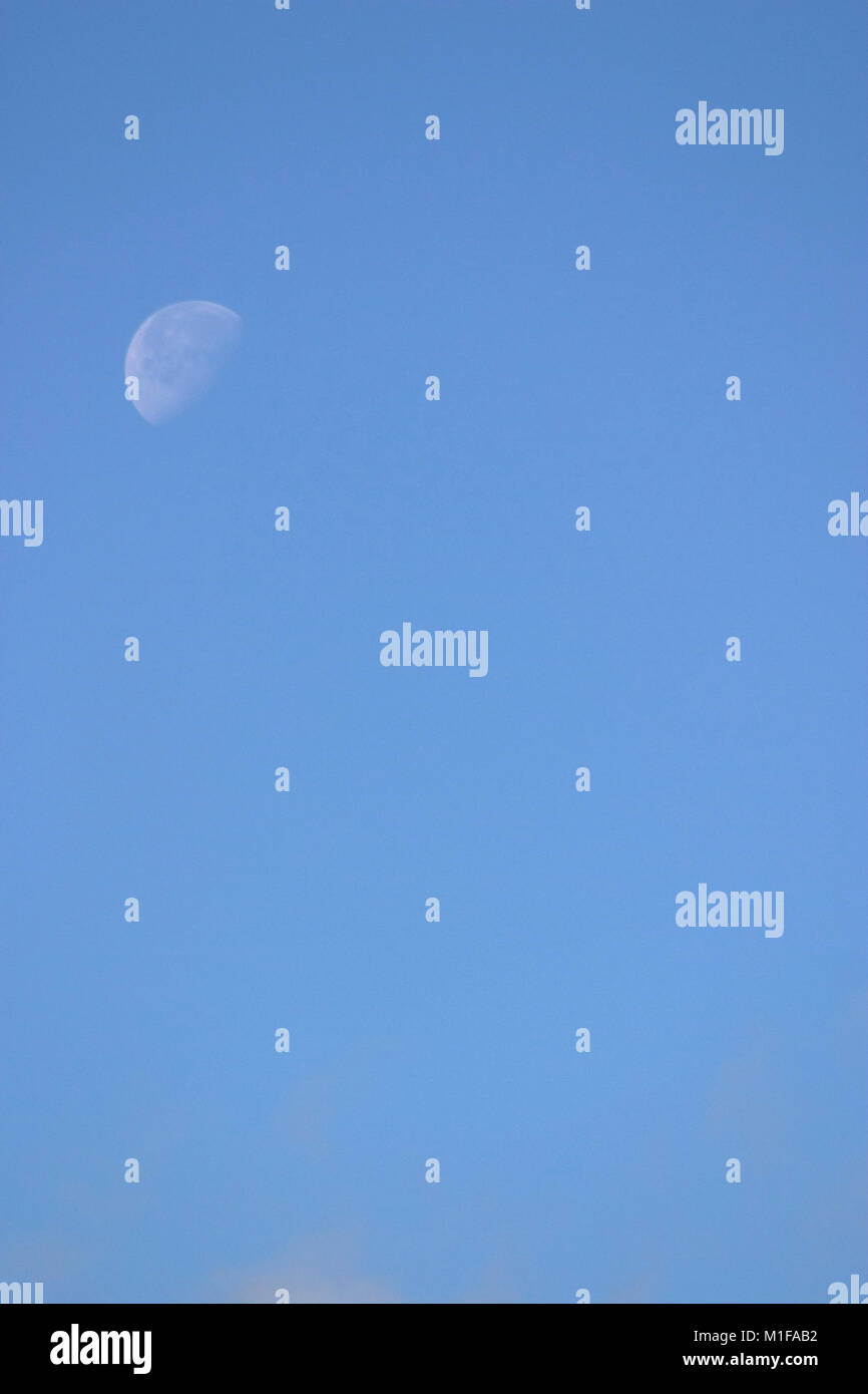 Three quarter moon in a pure blue sky Stock Photo - Alamy