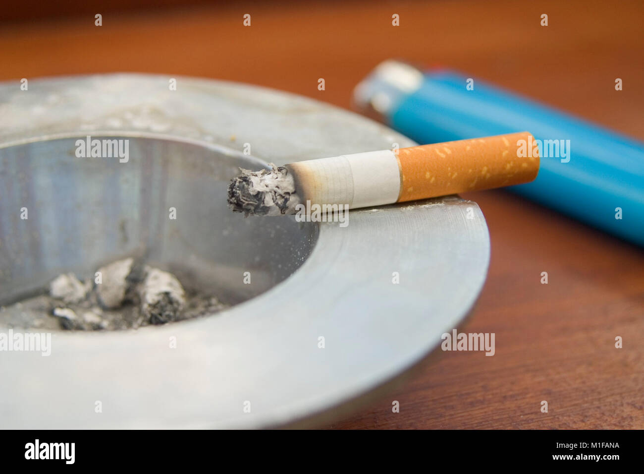 Burning cigarette smoking on ashtray Stock Photo - Alamy
