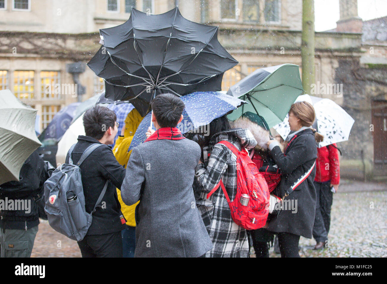 tourists getting a soaking in the rain and high winds in Cambridge as ...