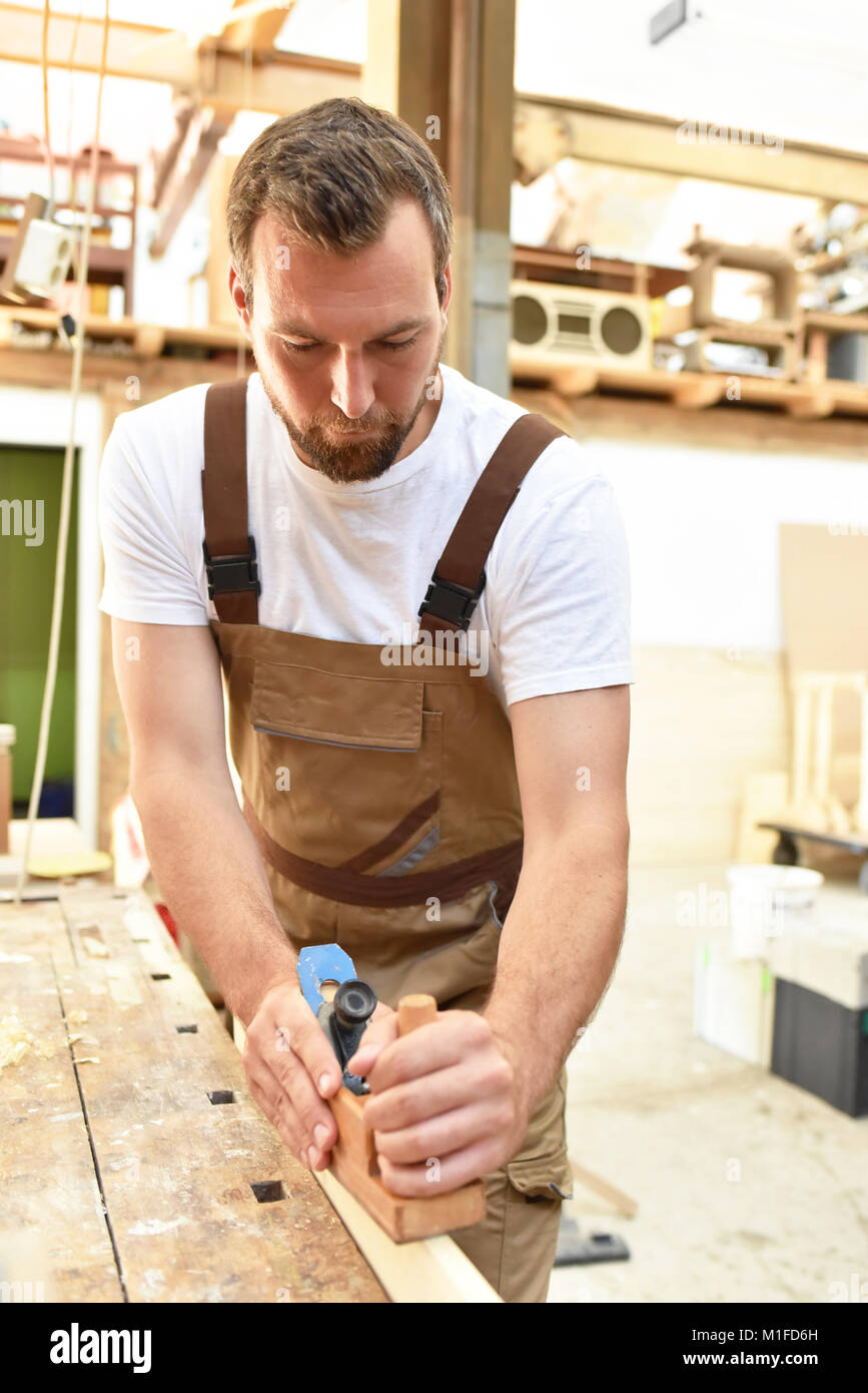 carpenter works in a joinery - workshop for woodworking and sawing ...