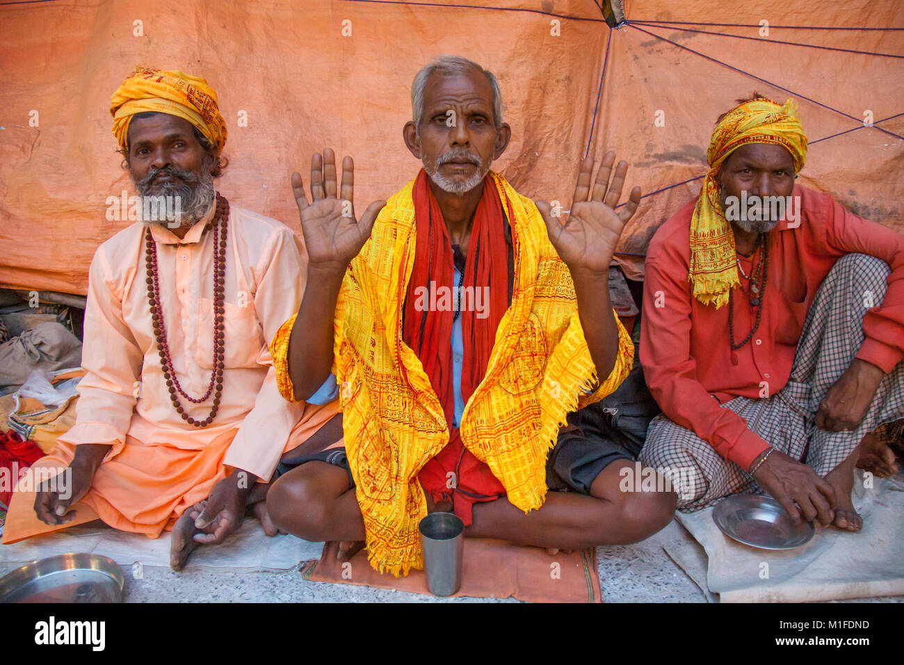 Three sadhus holy men sitting on the street in Varanasi, Uttah Pradesh ...
