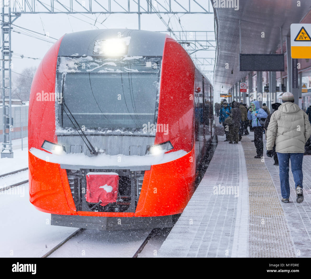 Highspeed train stands at the station platform at winter evening time ...