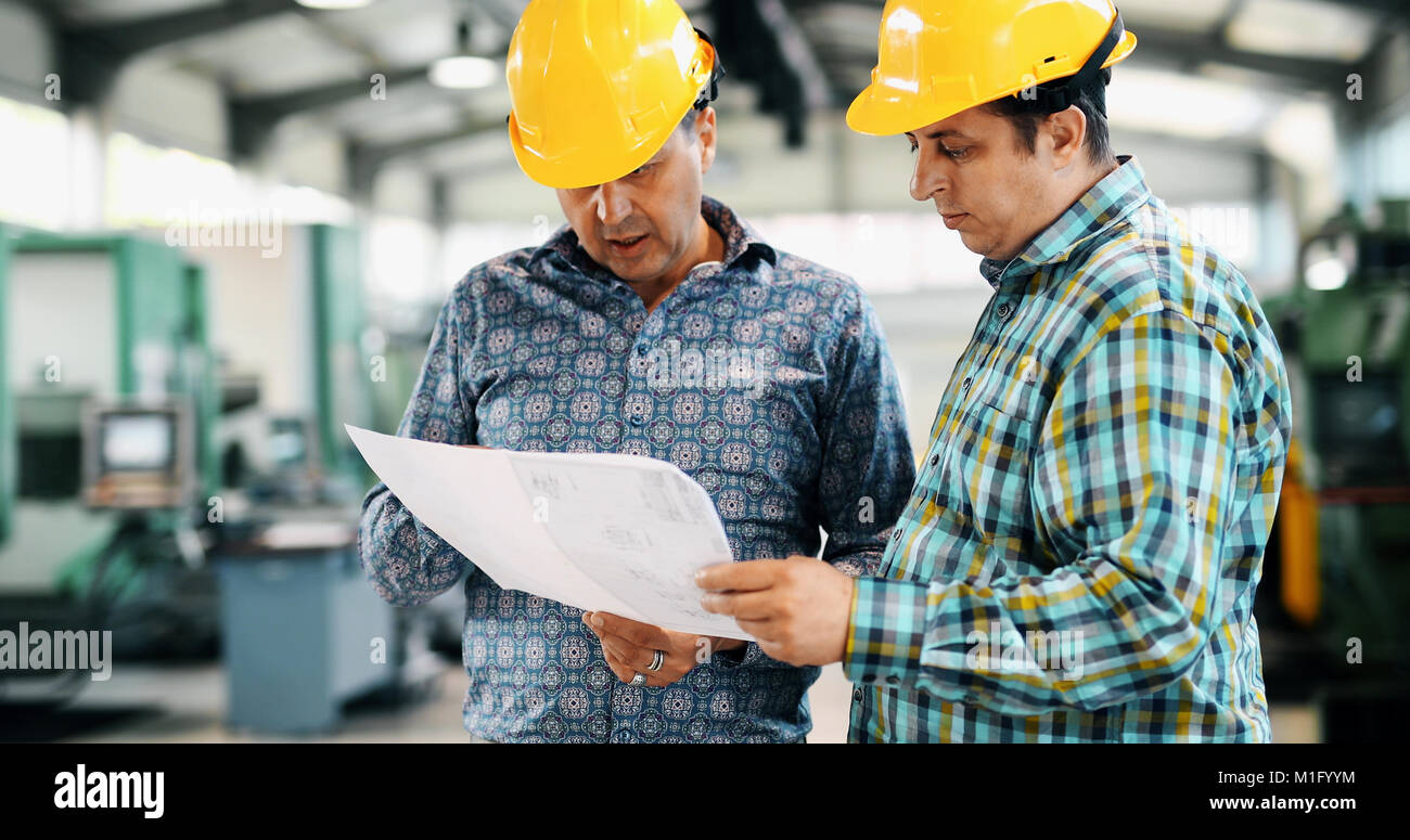 Factory worker discussing data with supervisor in metal factory Stock ...