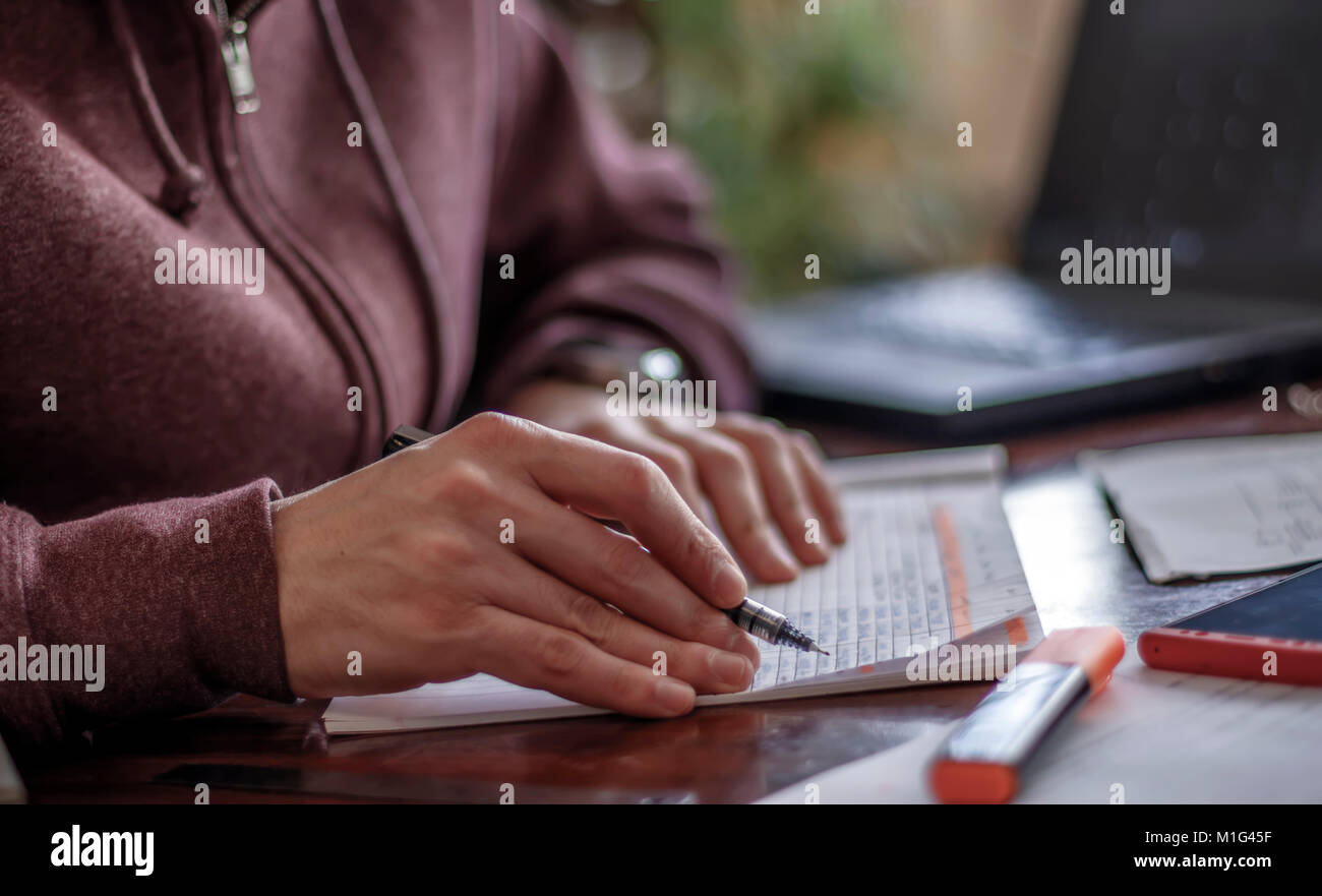 The hand of a man with a pen checking a homework in a notebook Stock ...