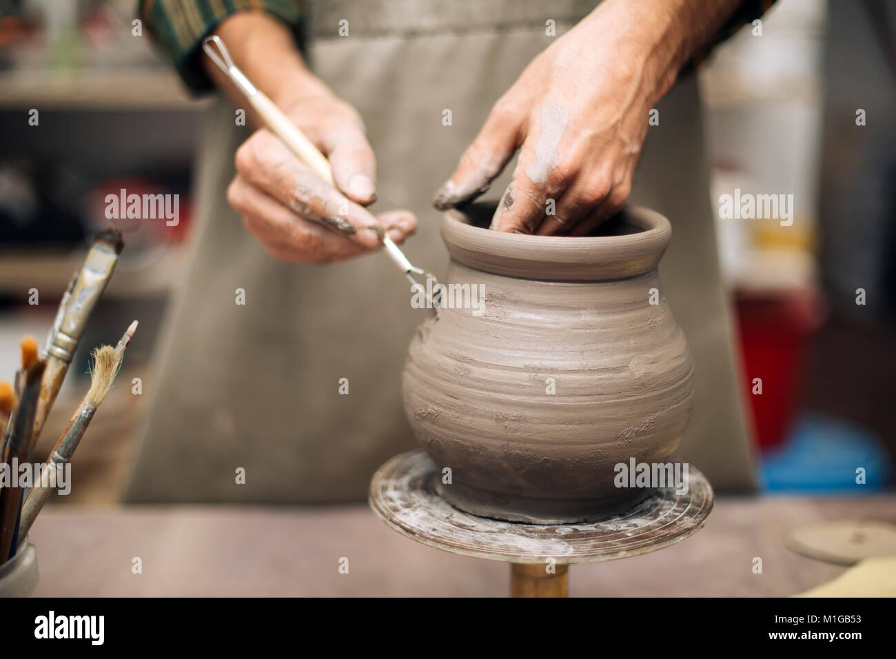 Young man making and decorating pottery in workshop Stock Photo - Alamy