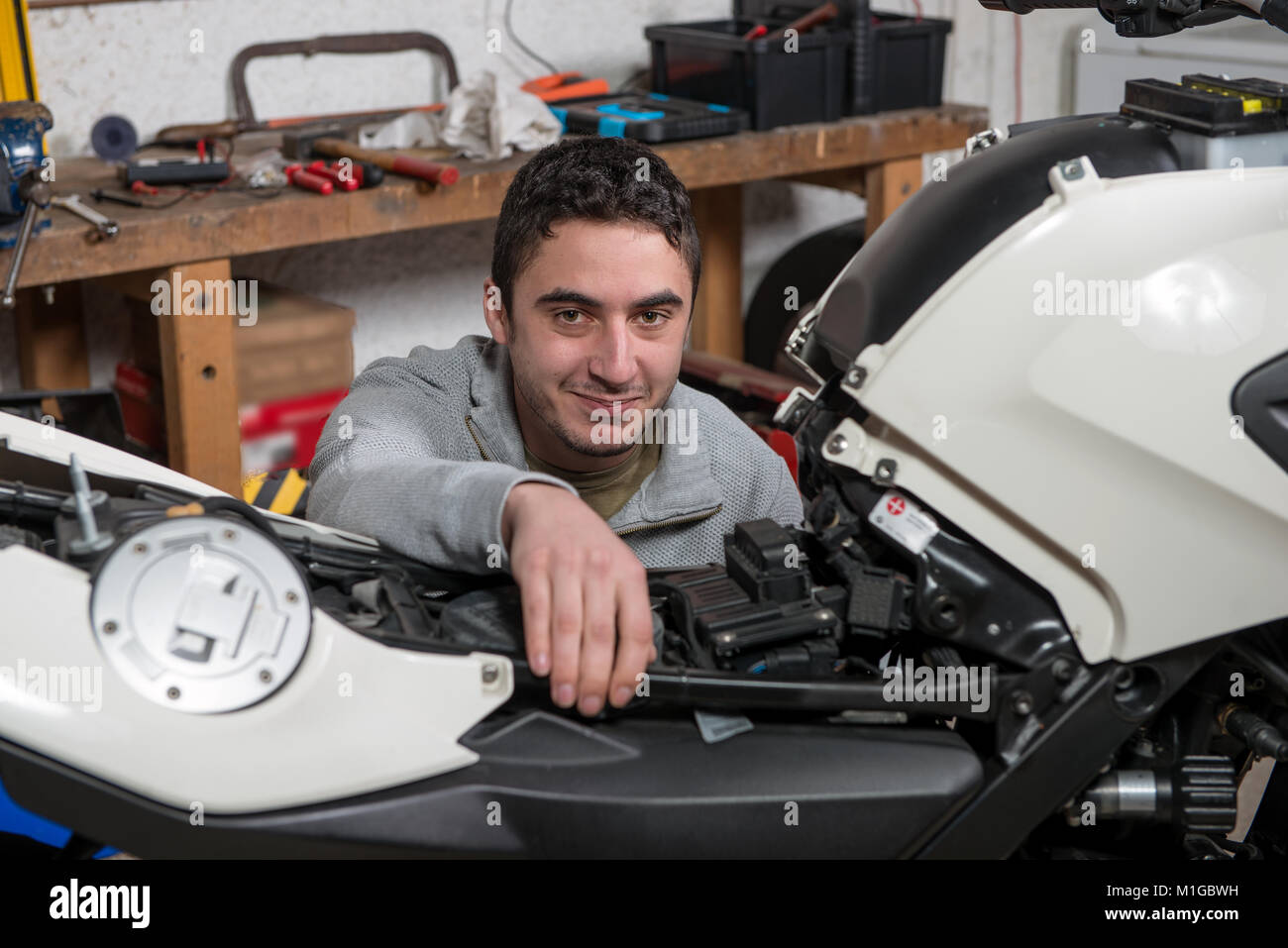 a young man repairing the motorcycle Stock Photo - Alamy