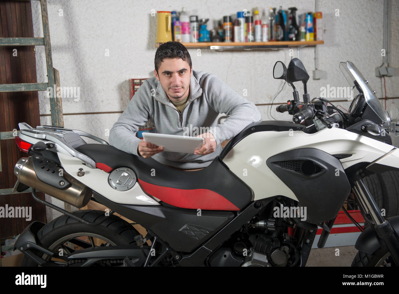 Man using tablet next to motorcycle workshop hi-res stock photography ...