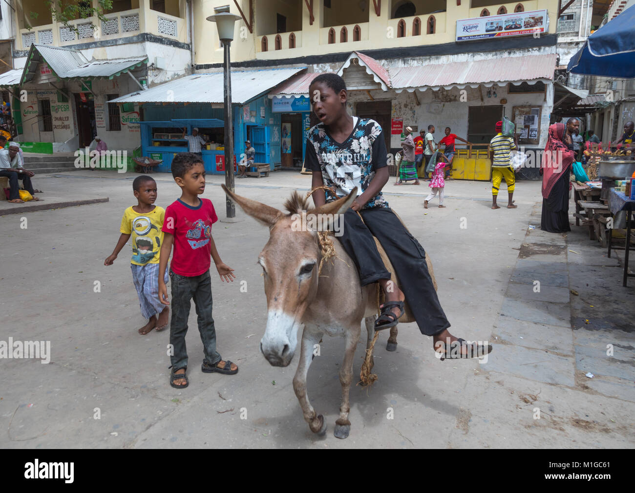Child riding a donkey on a square, Lamu County, Lamu Town, Kenya Stock ...