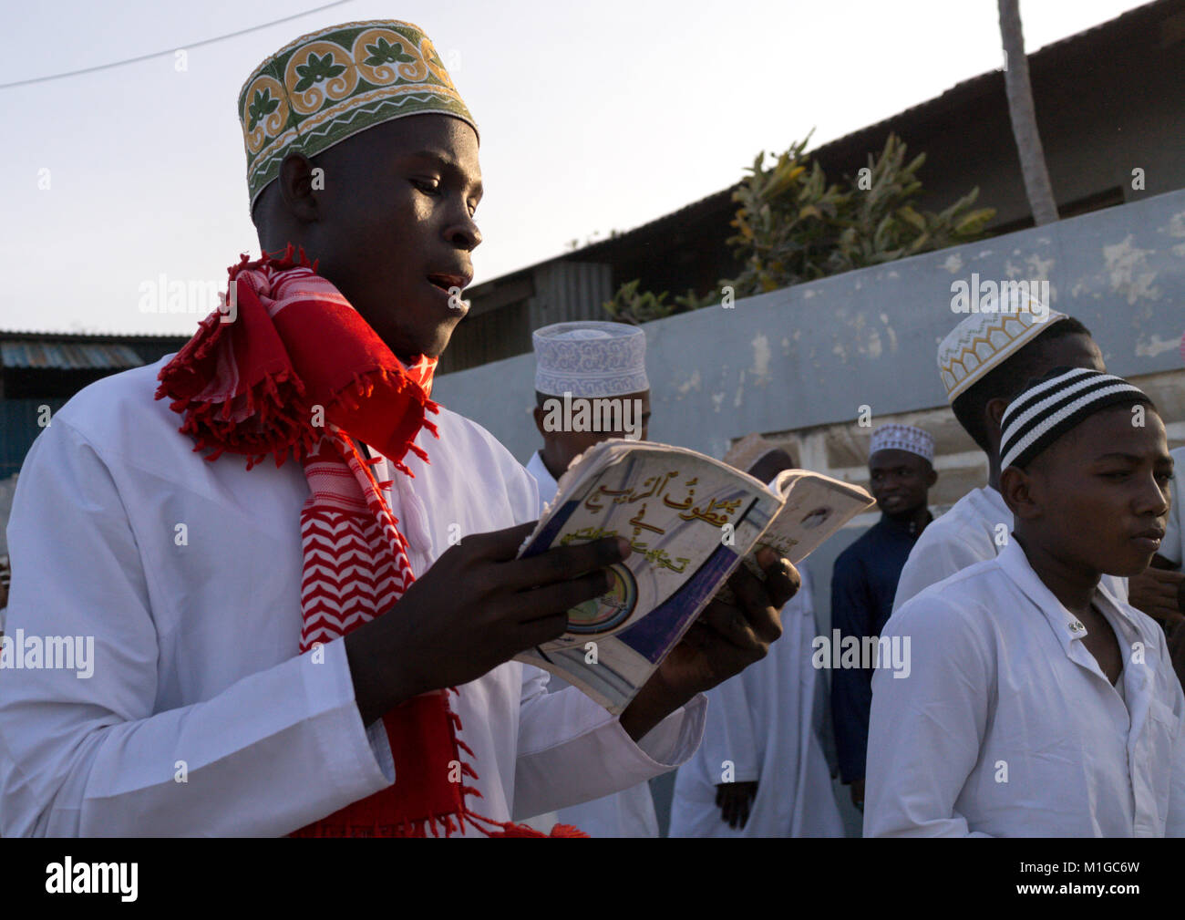 Sunni muslim man reading a religious book during the Maulidi ...